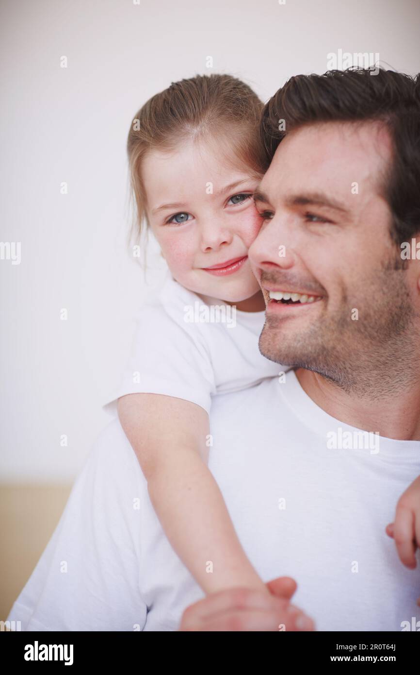 Hes devoted to his daughter. A cute little girl lovingly embracing her ...