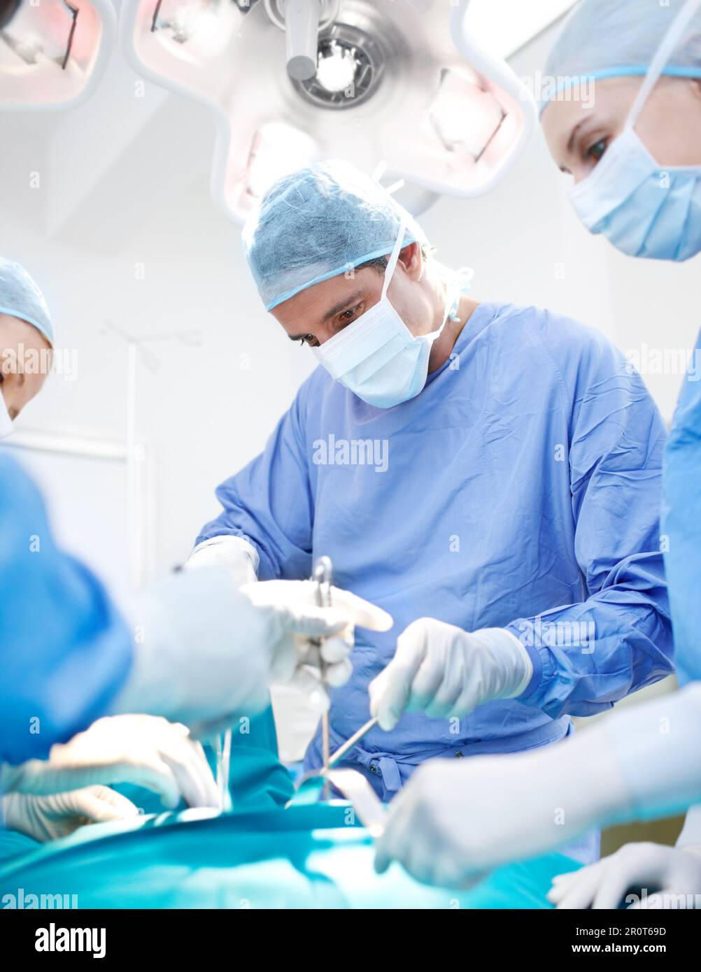 Surgical precision. Side profile of a male doctor performing surgery ...