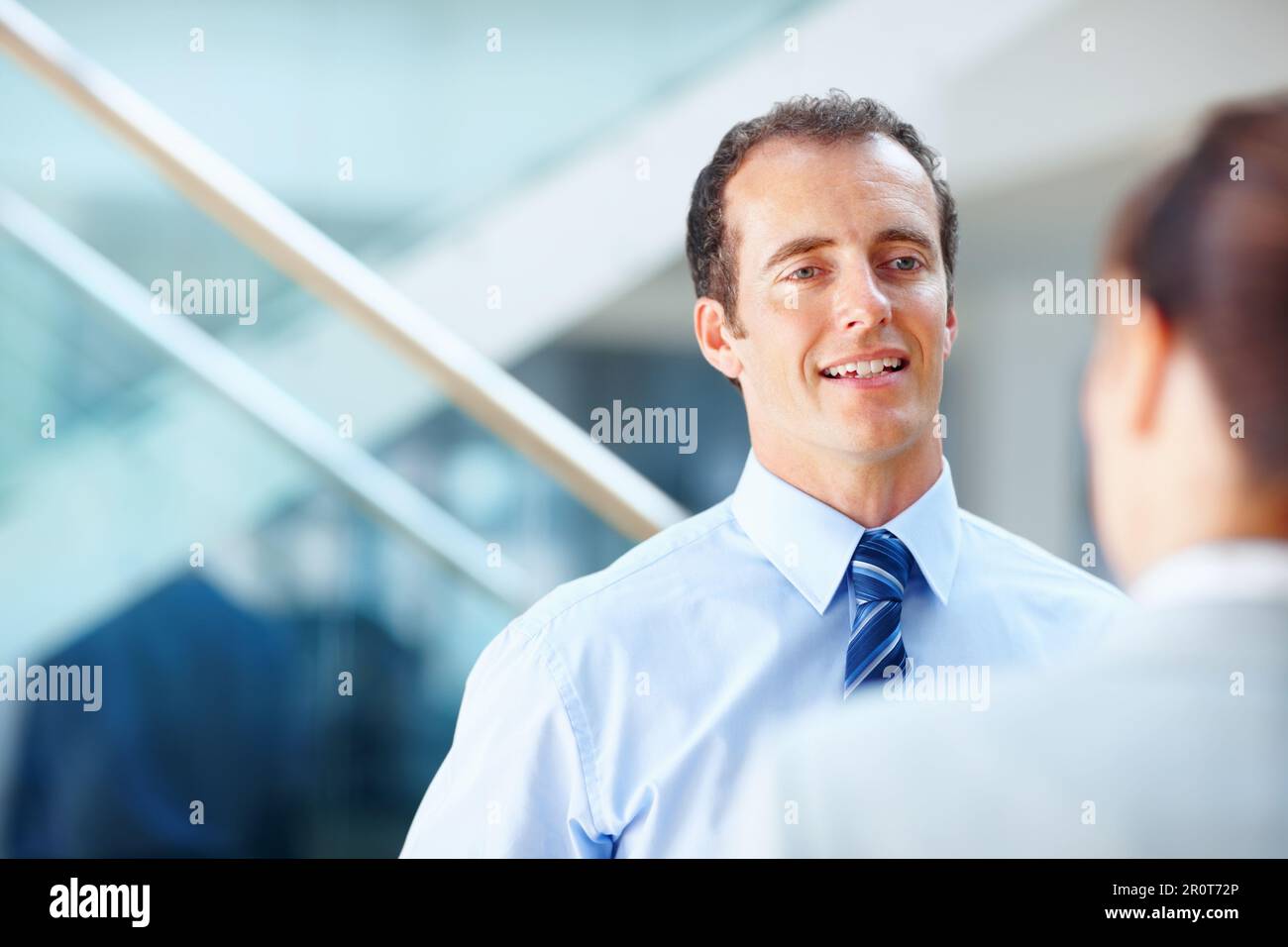 An office executive having conversation with his colleague. Portrait of ...