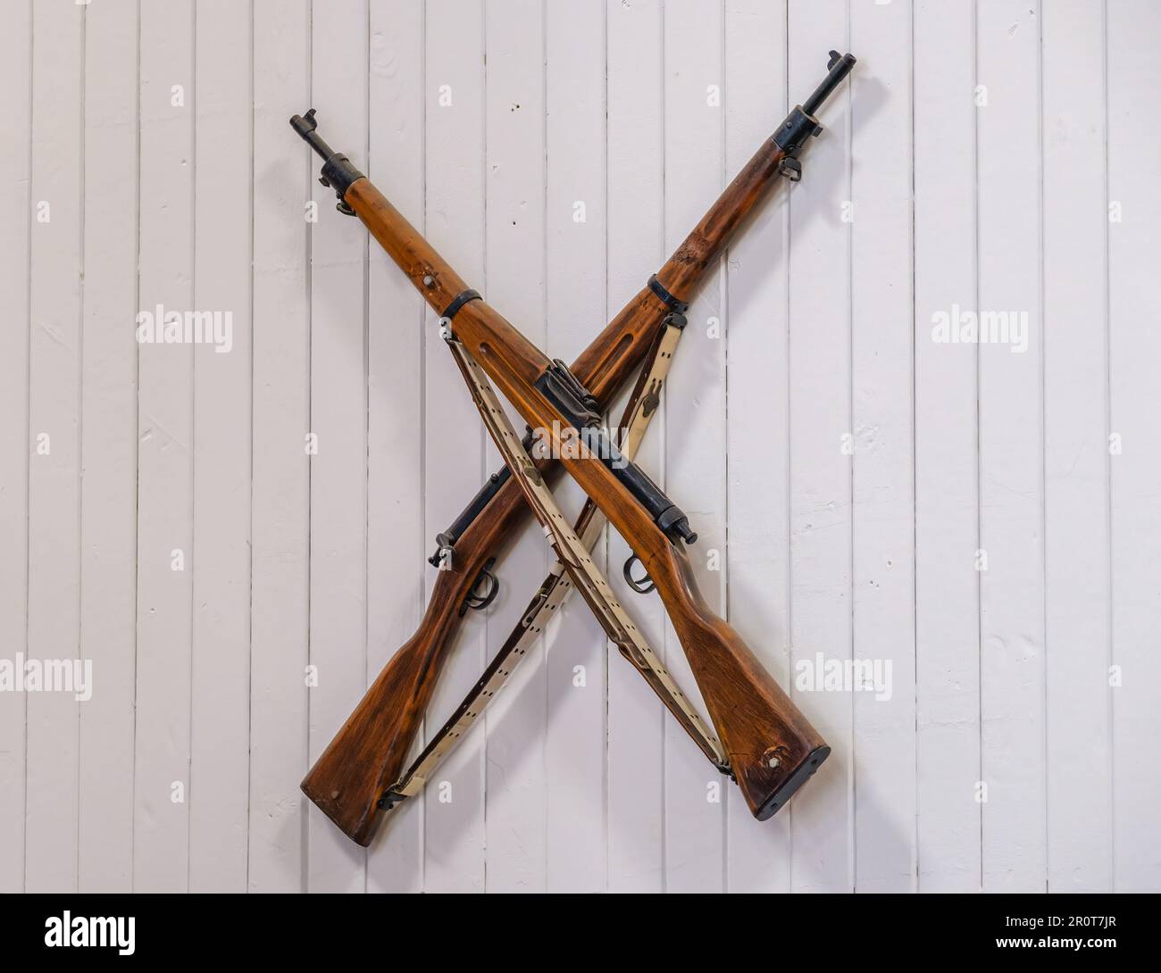 Two crossed military rifles decorate the interior wall of a military ...
