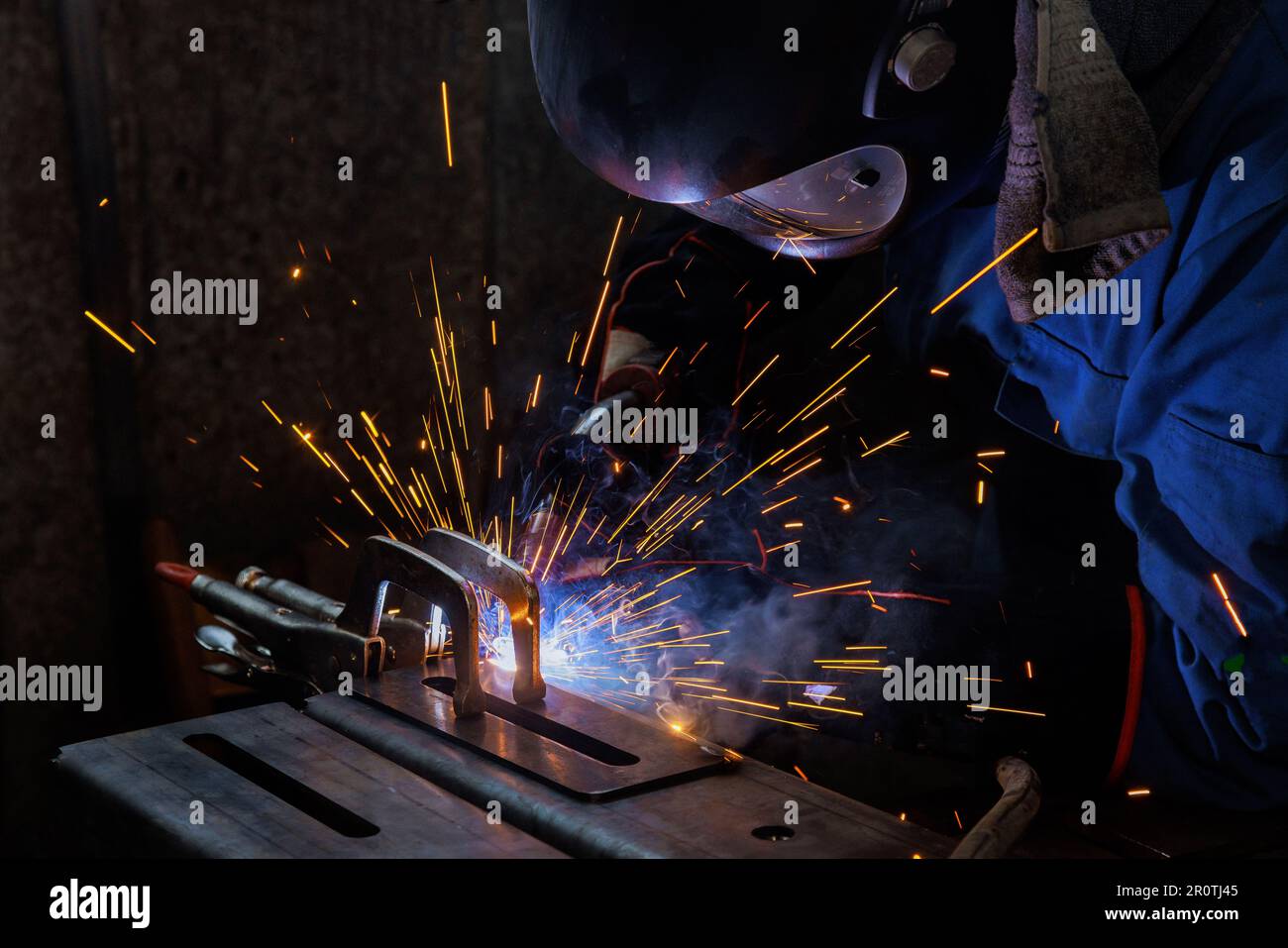 Workplace where worker is welding steel at work sparks are lighting up ...