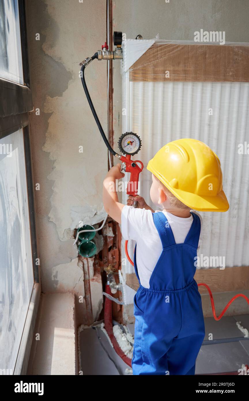 Kid using air compressor manometer while checking gas tightness of ...