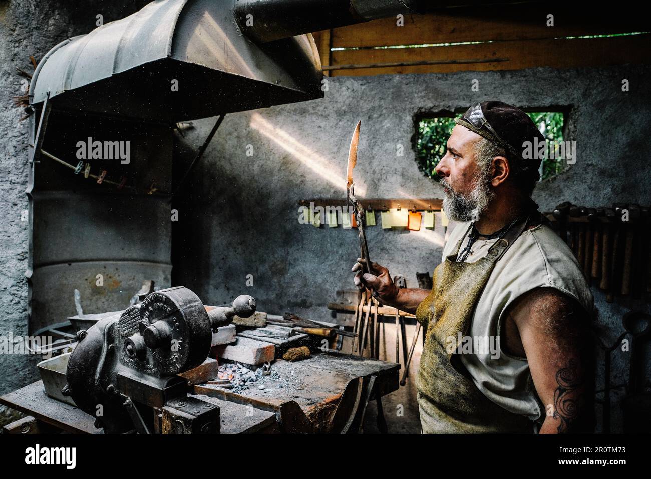 A blacksmith using a large knife to craft an interesting object in his ...