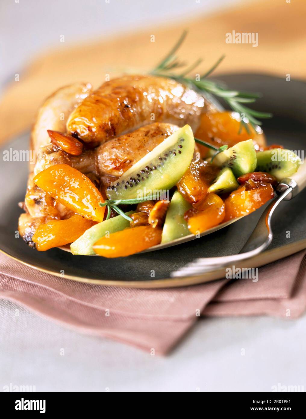 Roast young cockerel with kiwis and dried fruit Stock Photo - Alamy