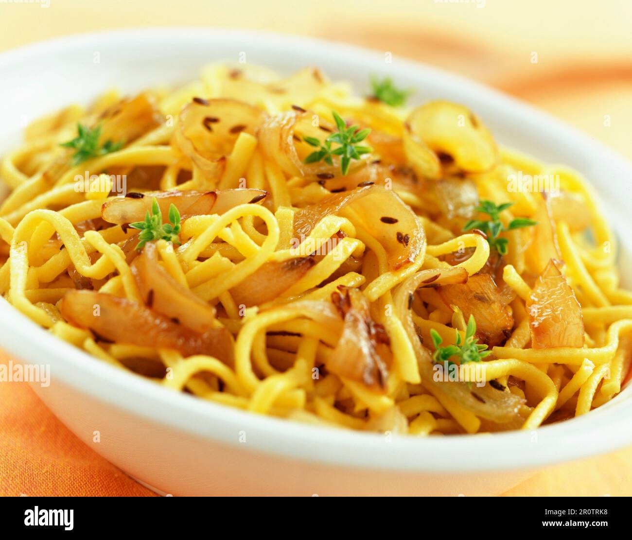 Spatzle fried noodles with onion and coriander Stock Photo - Alamy
