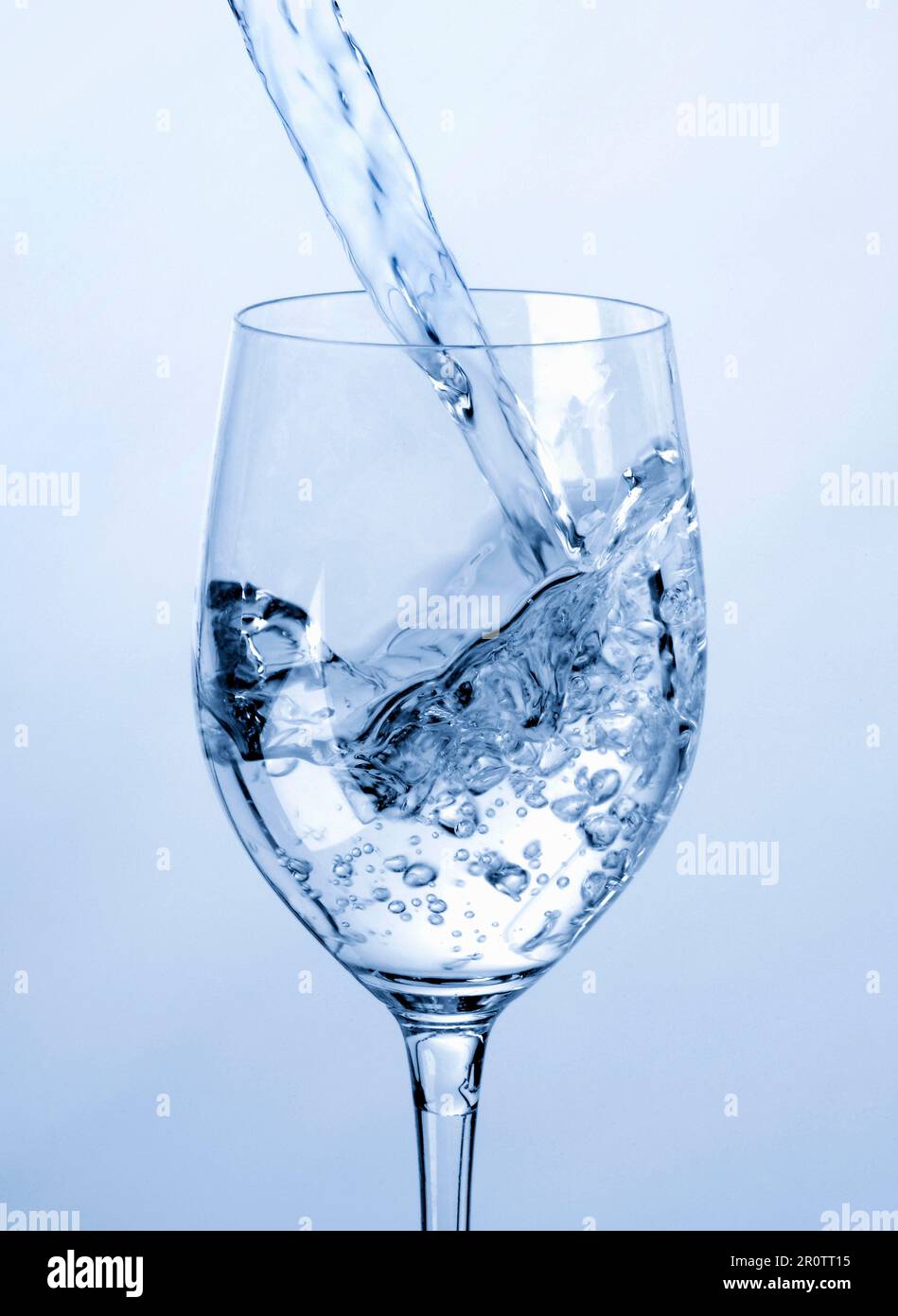 Pouring water into wine glass Stock Photo - Alamy