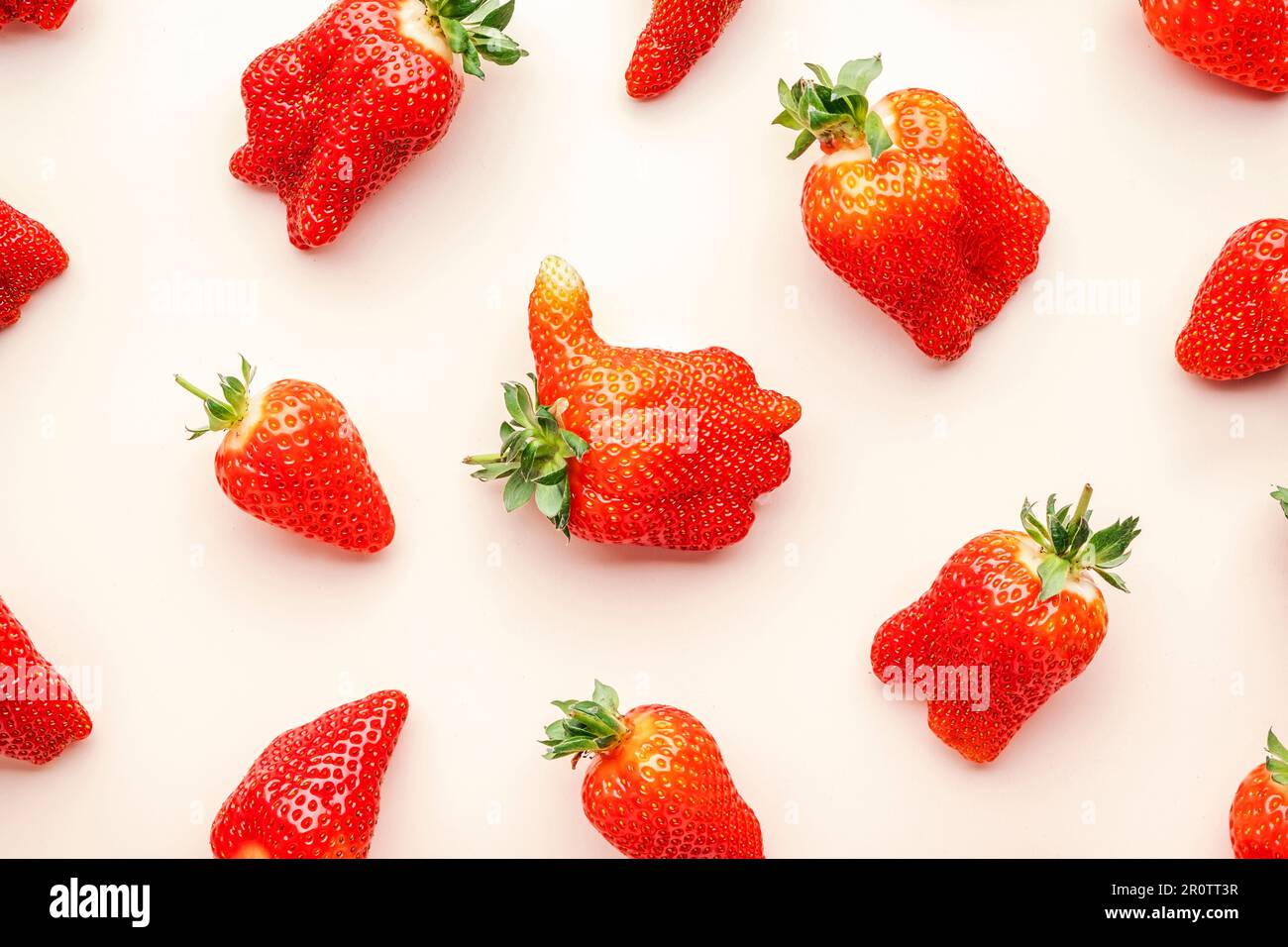 Fresh strawberries, different in shape and size, flat lay, light beige ...