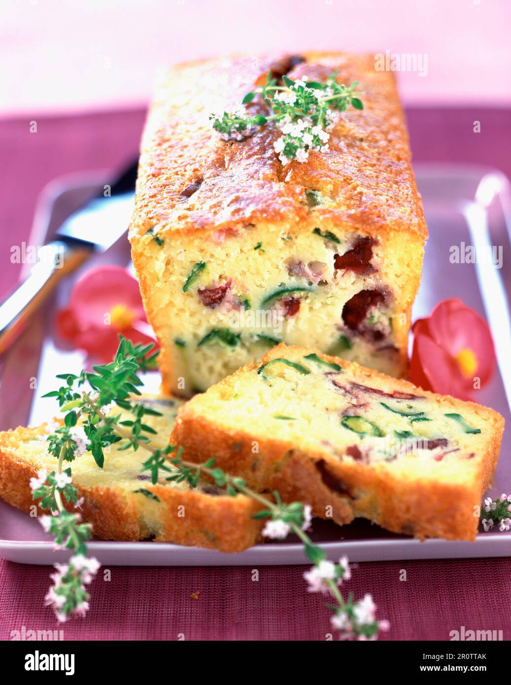 Savoury cake with courgettes, thyme and begonia flowers Stock Photo - Alamy
