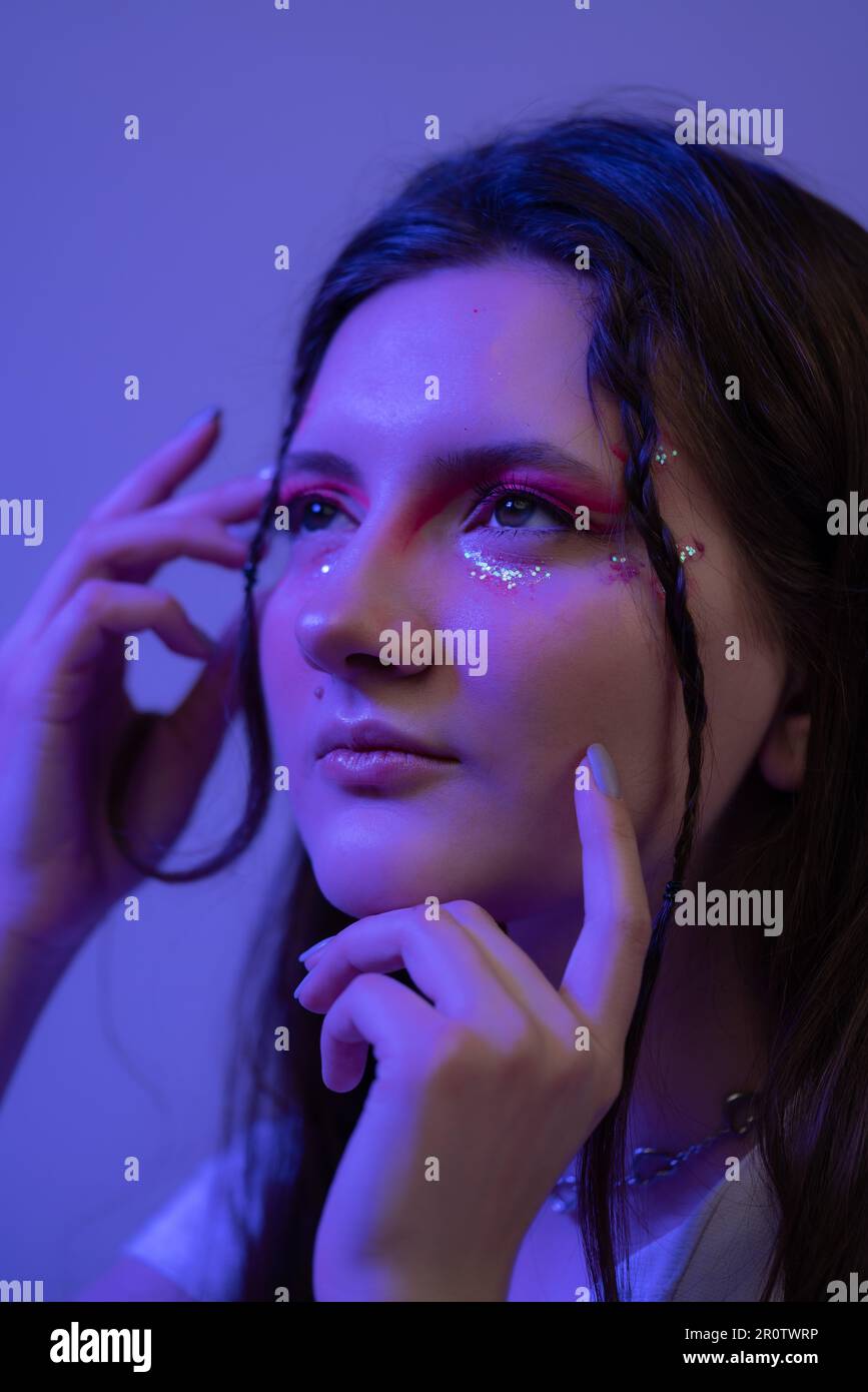 Portrait of woman face with shiny stage make-up with sequins and arrows ...
