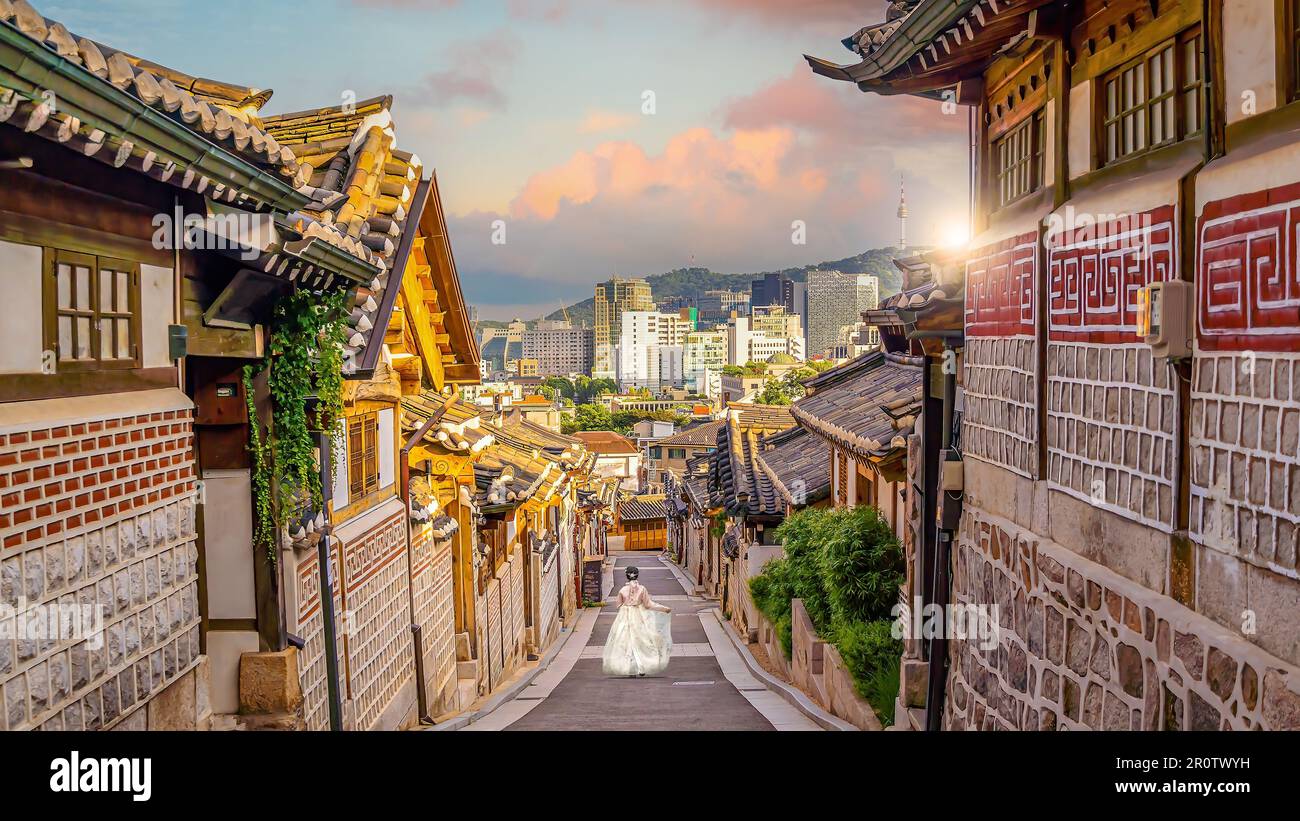 Girl wearing hanbok walking through Bukchon Hanok Village with Seoul ...