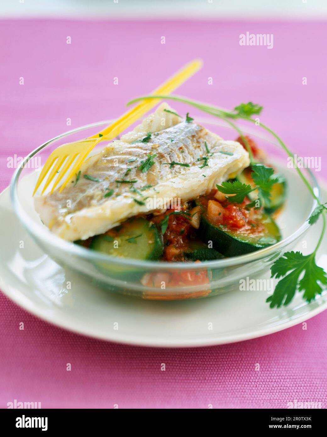 Steam-cooked cod with courgettes and tomatoes Stock Photo - Alamy