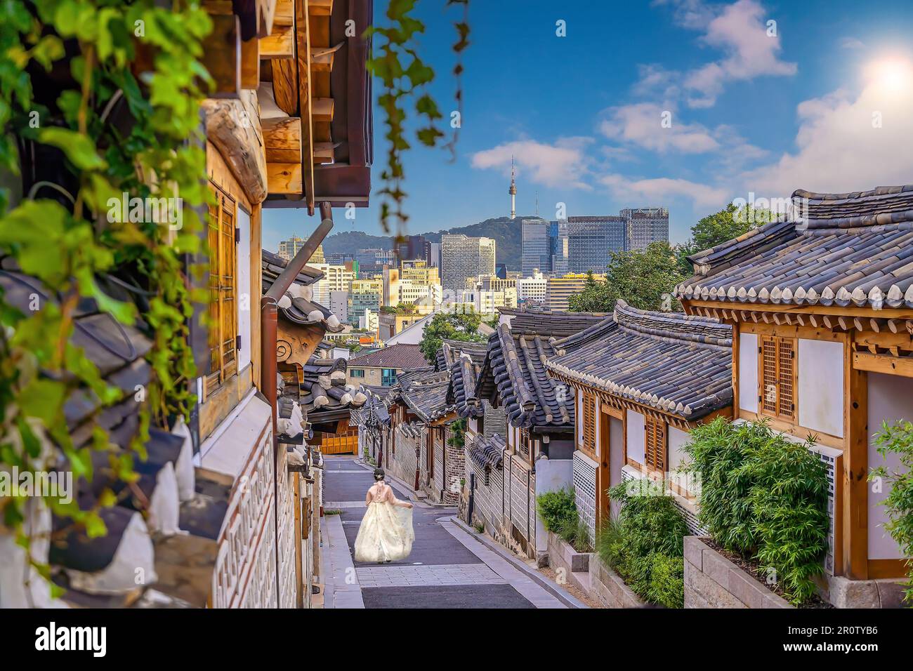 Girl wearing hanbok walking through Bukchon Hanok Village with Seoul ...