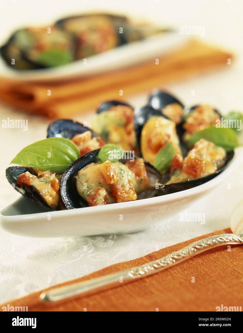 mussels au gratin with tomatoes and basil Stock Photo - Alamy