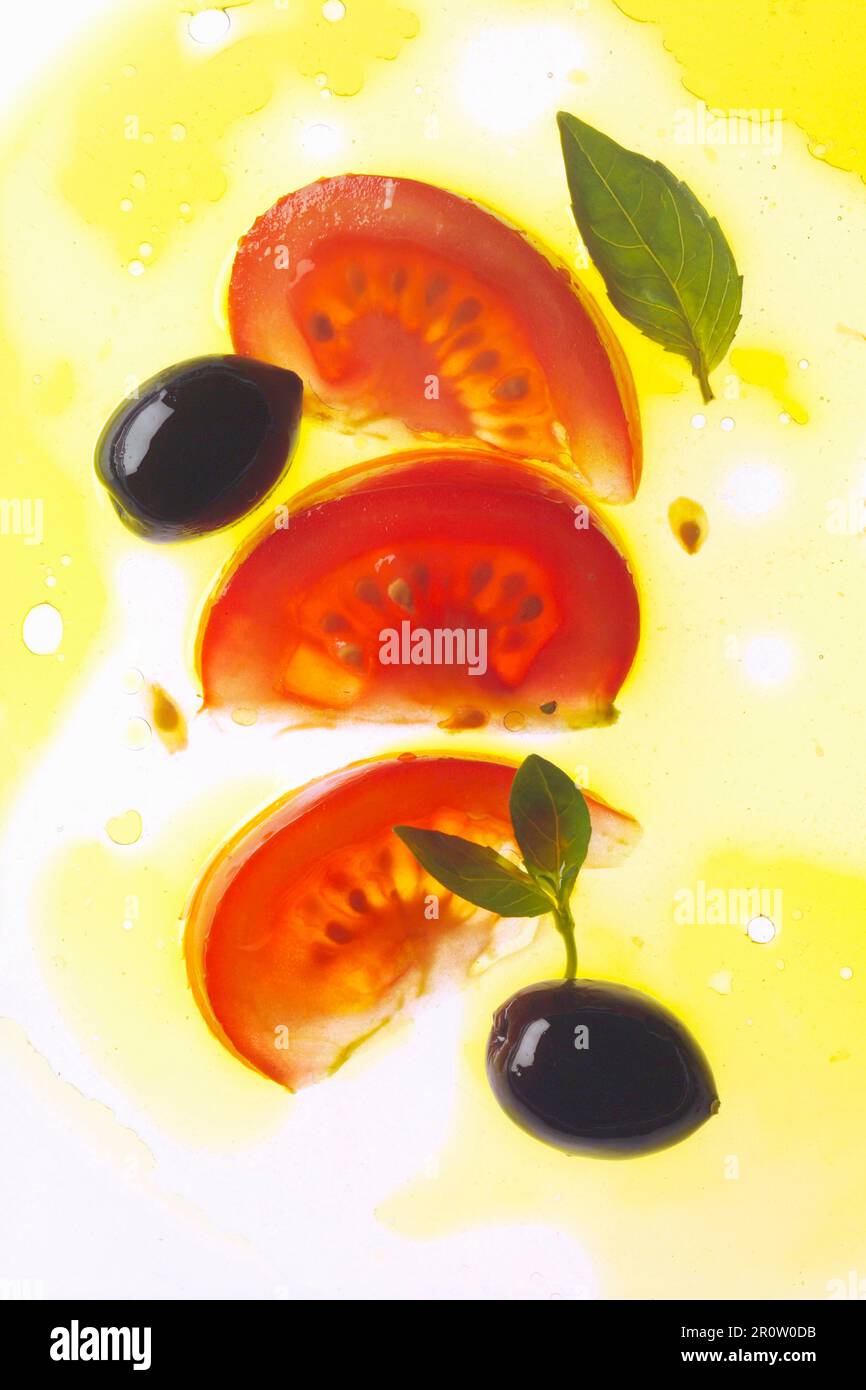 Cut tomato and olive in oil Stock Photo - Alamy