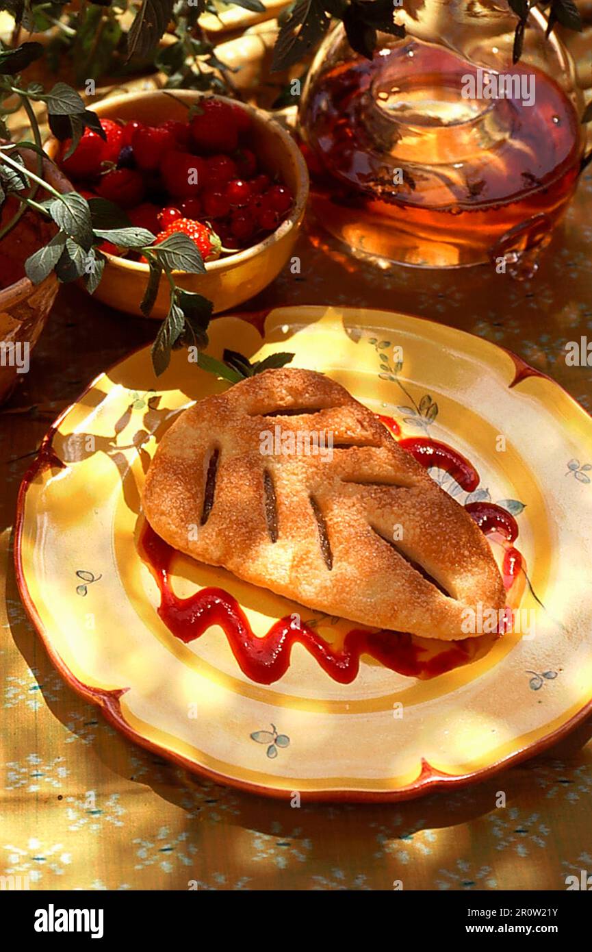 An apple turnover with fruits of the forest coulis Stock Photo - Alamy