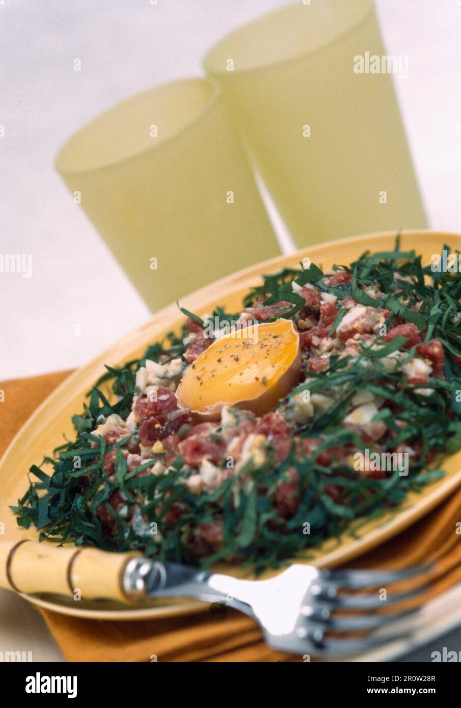 Beef tatar with a raw egg yolk and herbs Stock Photo - Alamy