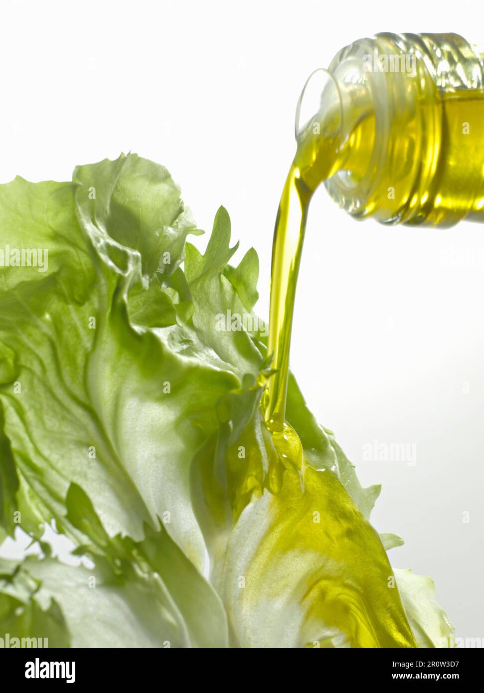 Pouring olive oil onto a lettuce leaf Stock Photo - Alamy