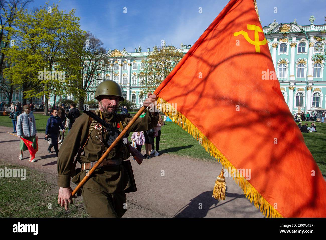 A man in a military uniform of 1945 holds a flag of the Soviet Union ...