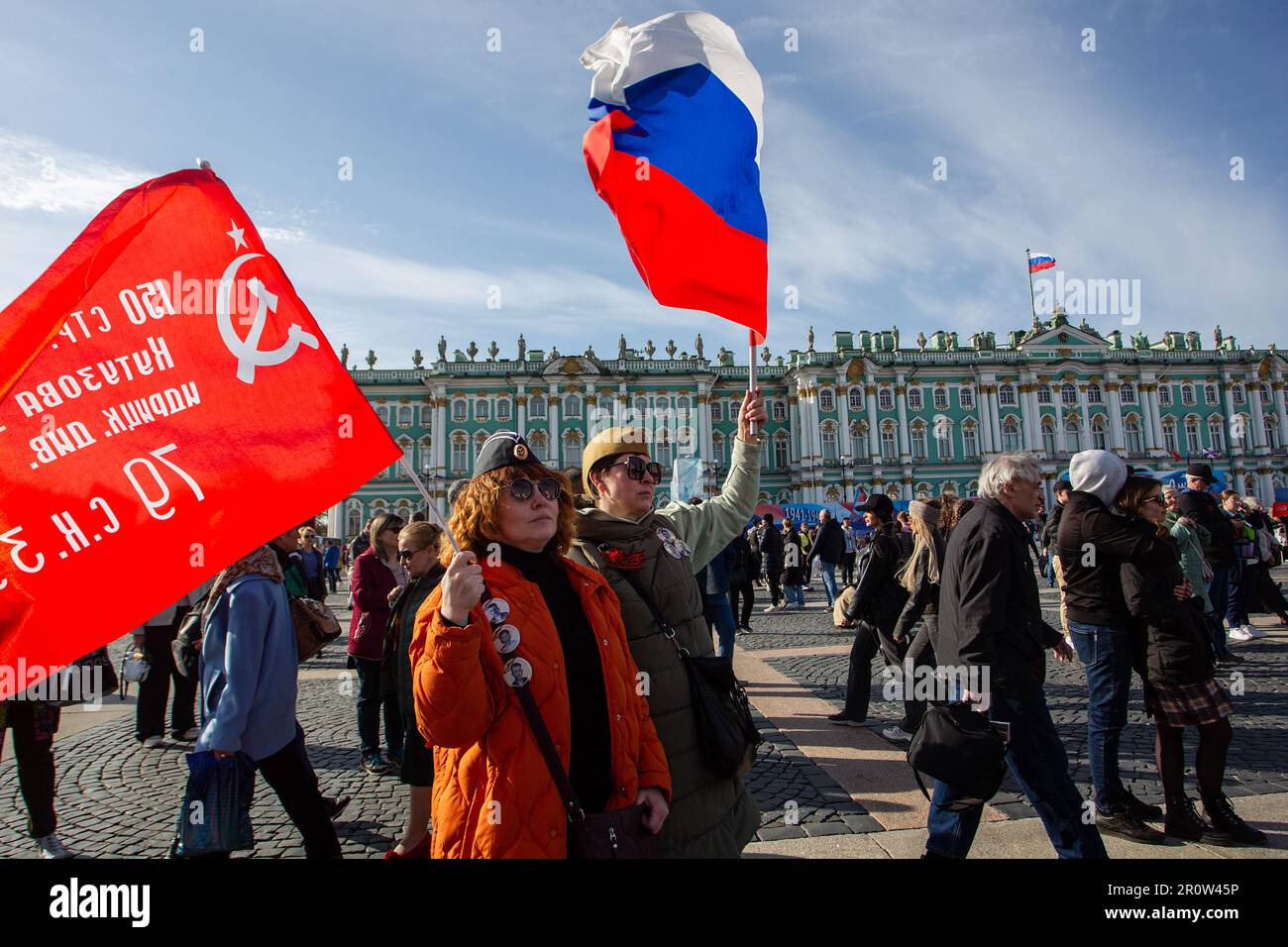 Citizens with the flags of Russia and the Soviet Union watch a festive ...