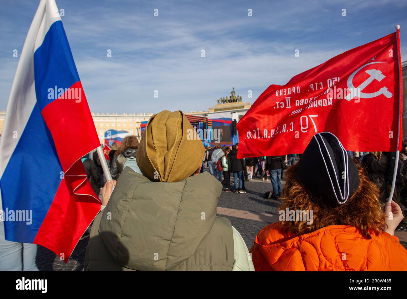 Citizens with the flags of Russia and the Soviet Union watch a festive ...