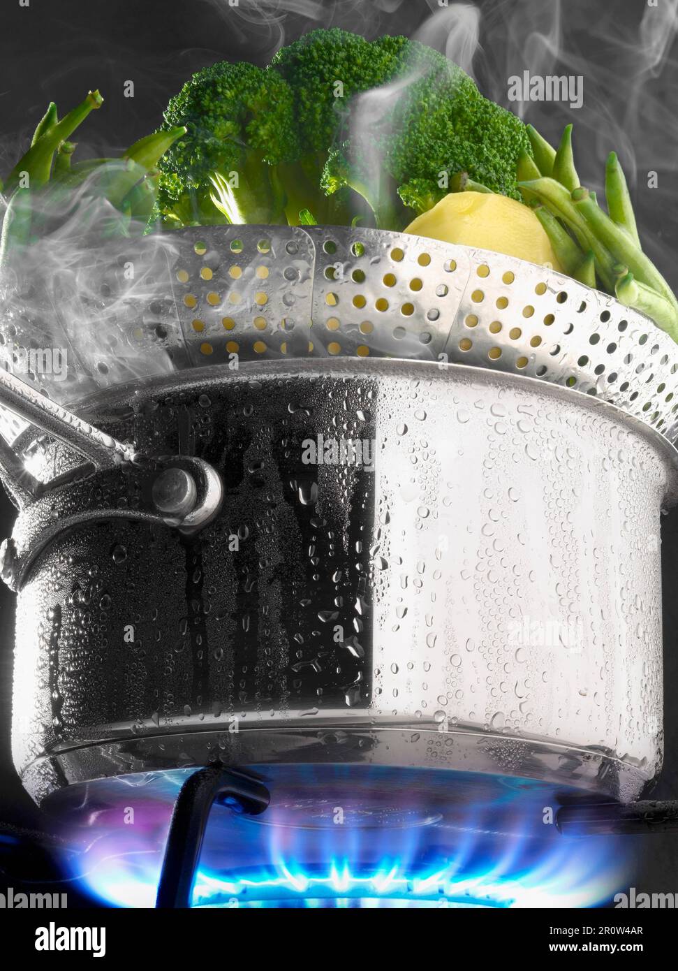 Steam cooking vegetables in a saucepan on a gas cooker Stock Photo - Alamy