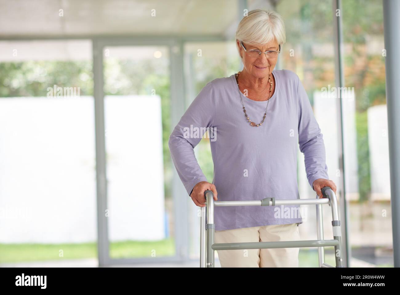 Post-surgery exercise is essential. a senior woman walking with care ...