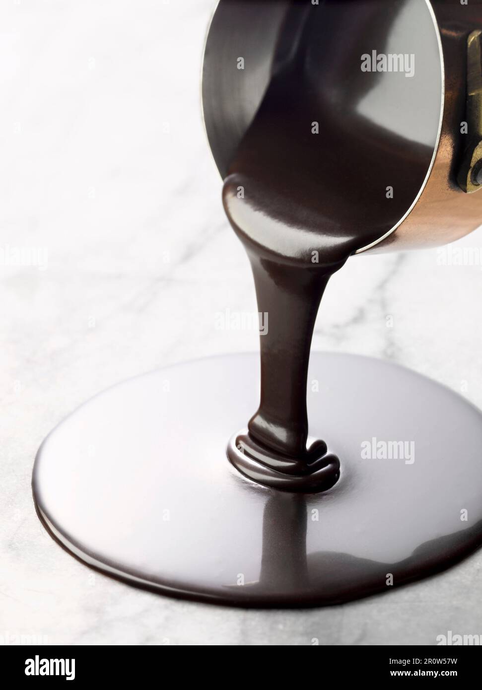 Pouring melted dark chocolate onto a slab of marble Stock Photo - Alamy