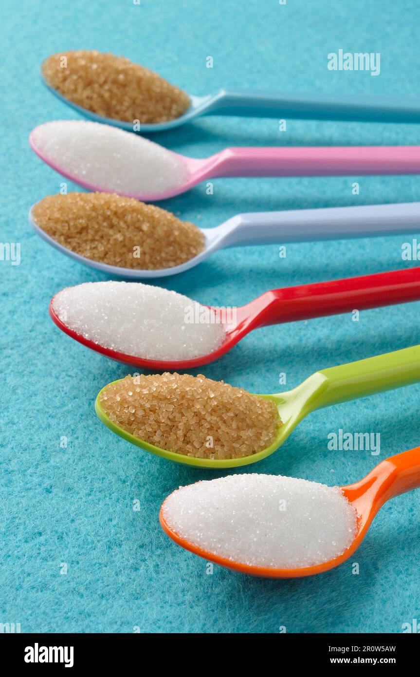 Plastic spoons with white and brown sugar Stock Photo - Alamy