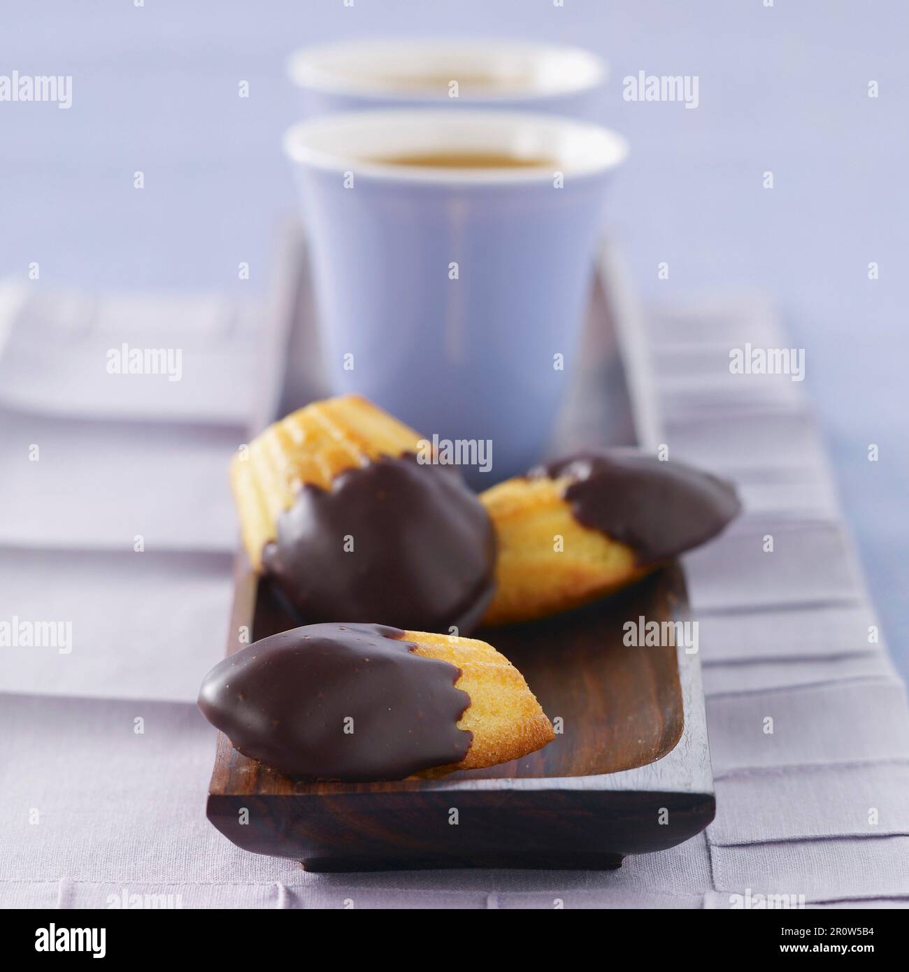 Madeleines half coated with chocolate Stock Photo - Alamy