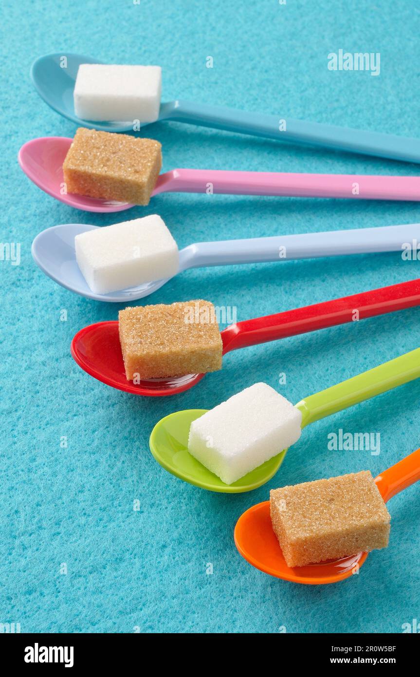 Plastic spoons with white and brown sugar lumps Stock Photo - Alamy
