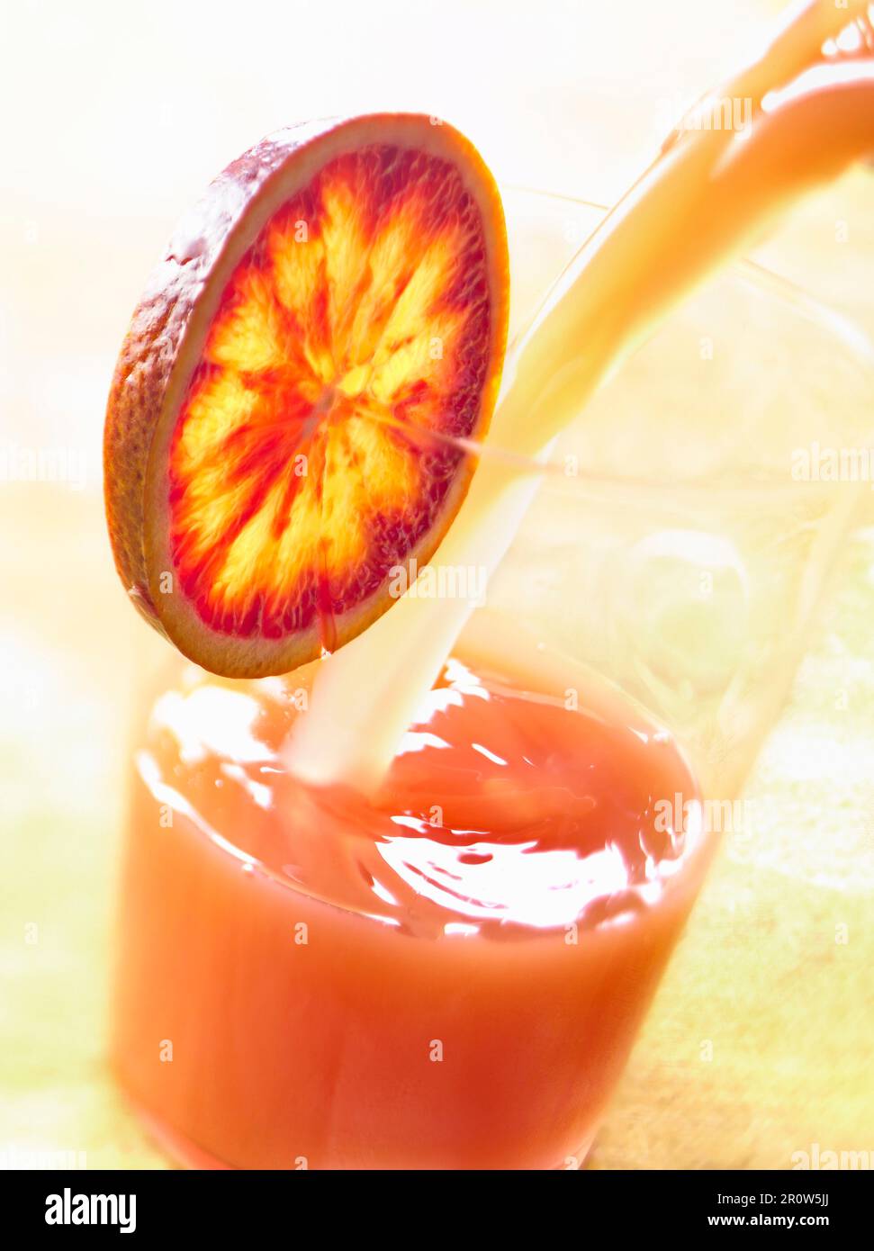Pouring a glass of blood orange juice Stock Photo - Alamy