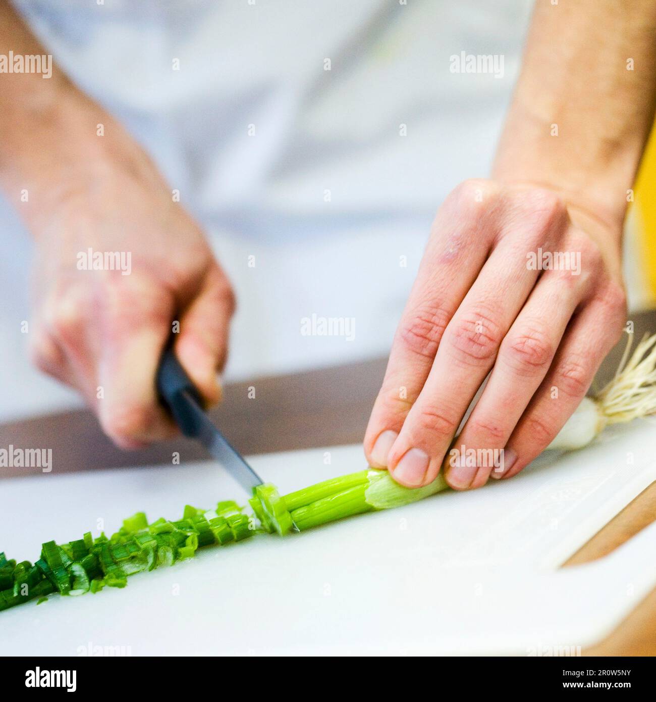 Cutting a spring onion into thin slices Stock Photo - Alamy