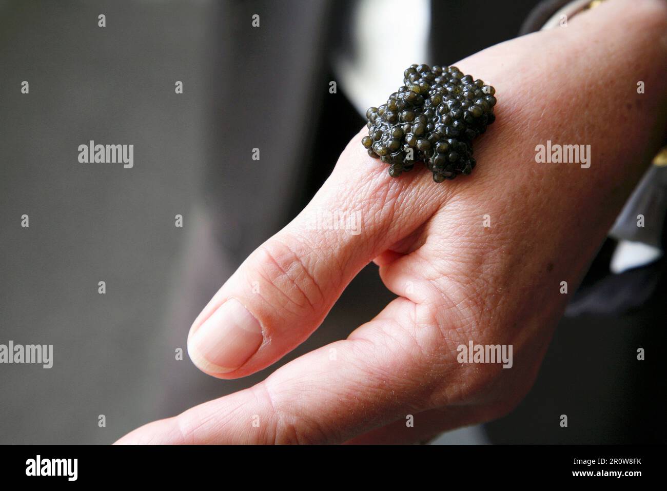 Placing a spoonful of caviar on a hand to taste Stock Photo - Alamy