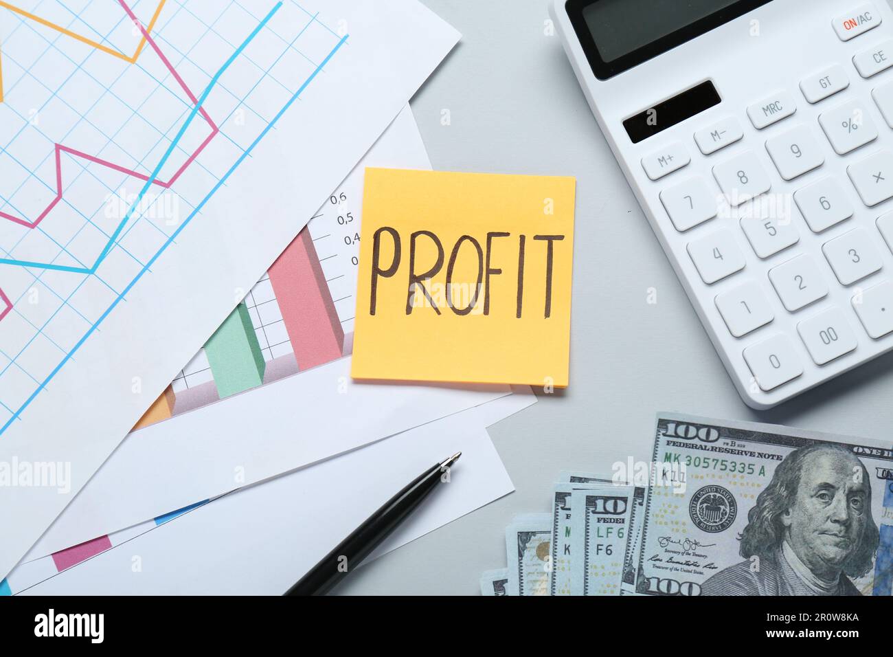 Sticky note with word Profit, calculator, banknotes and diagram on ...