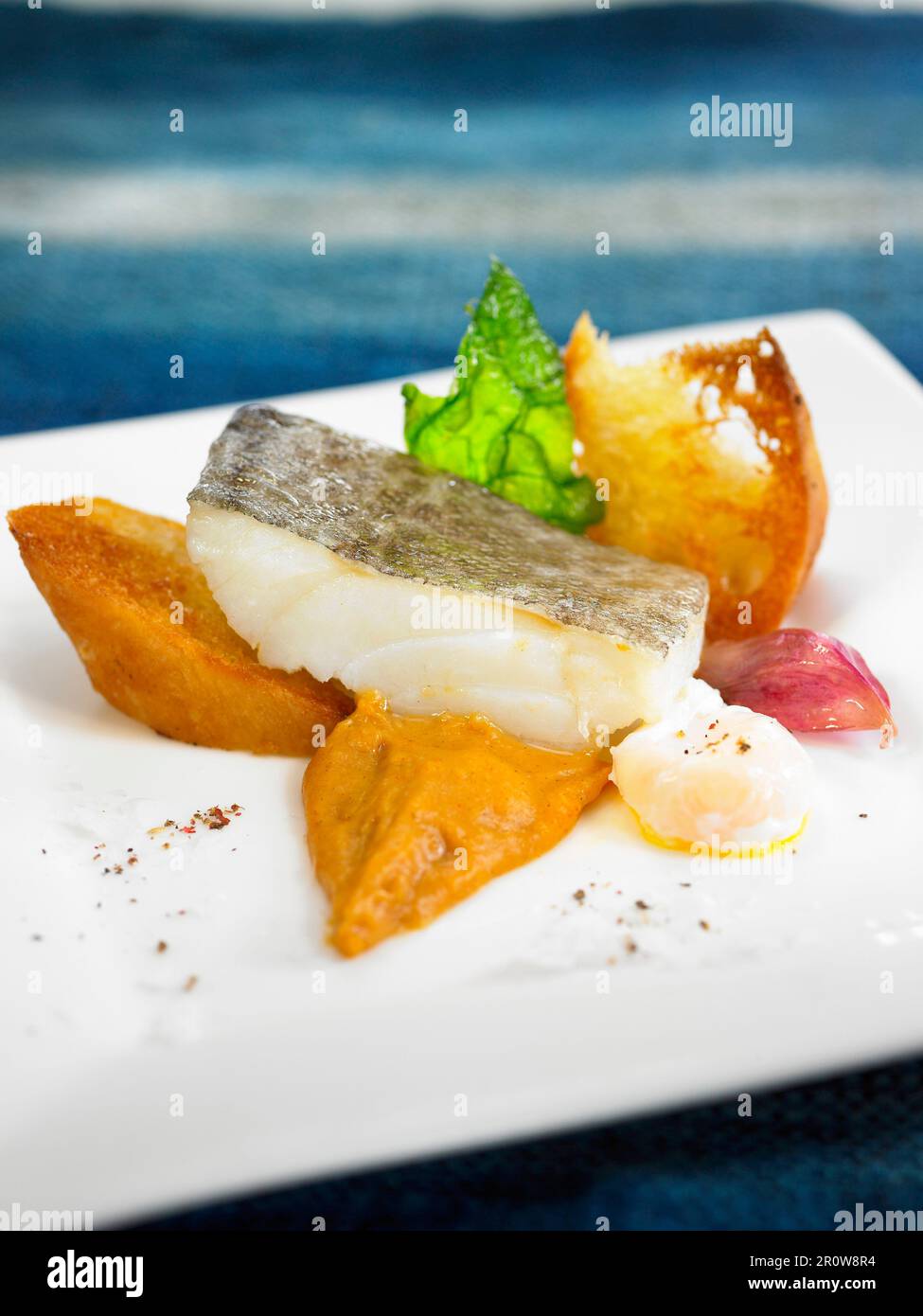 Thick piece of salt-cod with cream of red peppers Stock Photo - Alamy