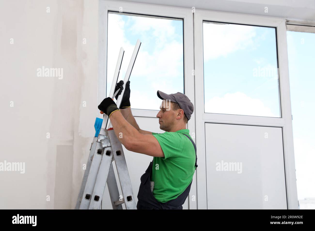 Worker with materials for window installation indoors Stock Photo - Alamy
