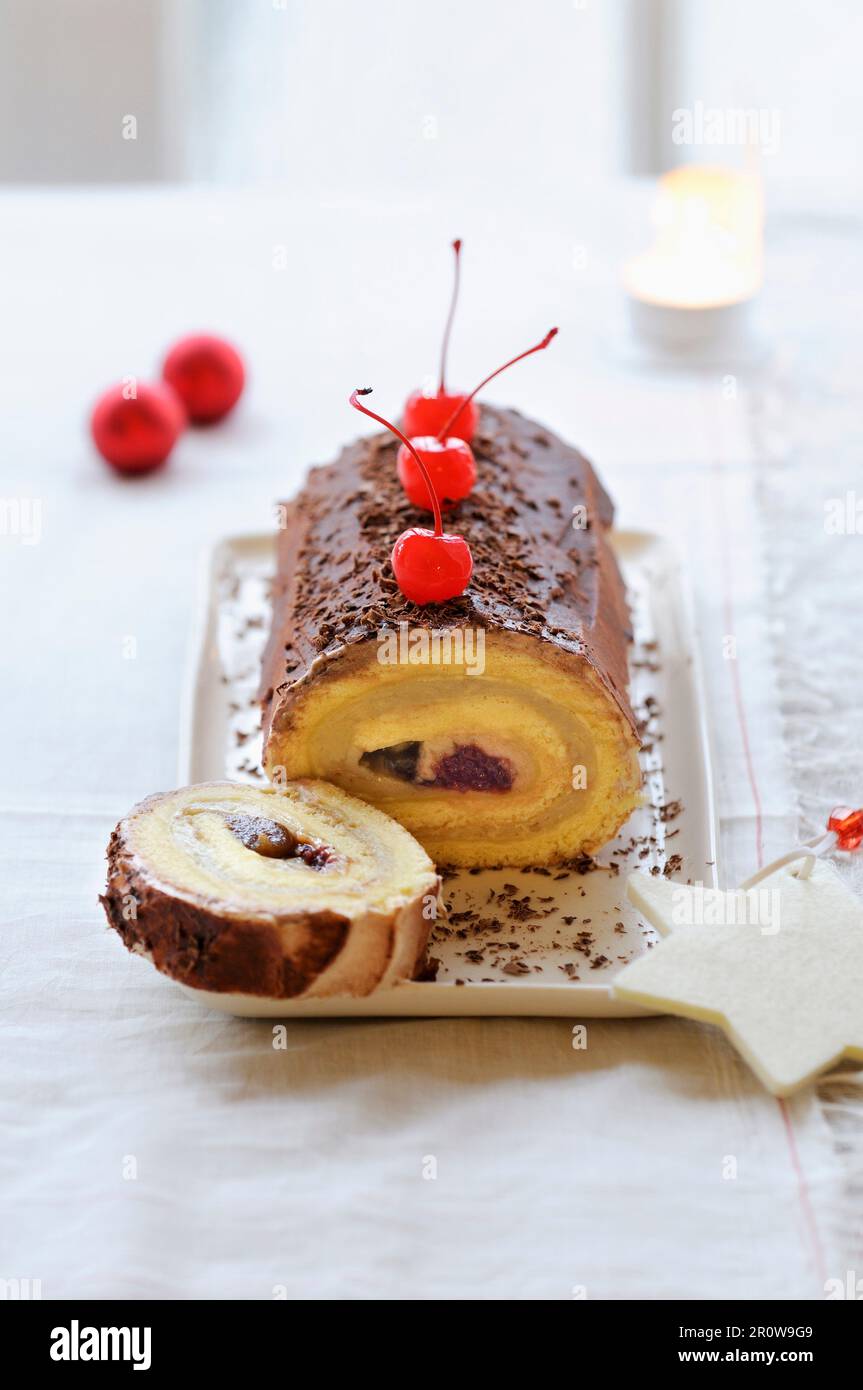 Chocolate and cherry rolled log cake Stock Photo - Alamy