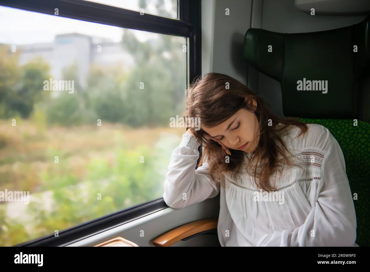 Teenage girl sleeping in train during trip Stock Photo - Alamy