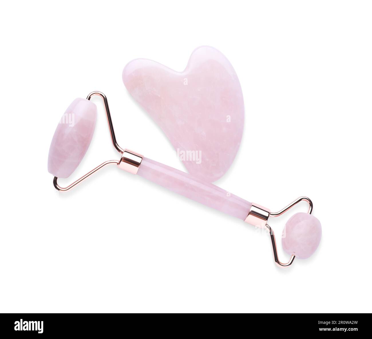 Rose quartz gua sha tool and facial roller isolated on white, top view ...