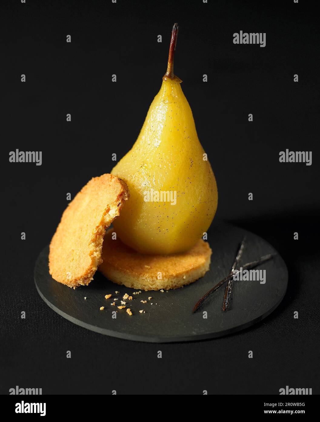 Vanilla-flavored poached pear with shortbread cookies Stock Photo - Alamy