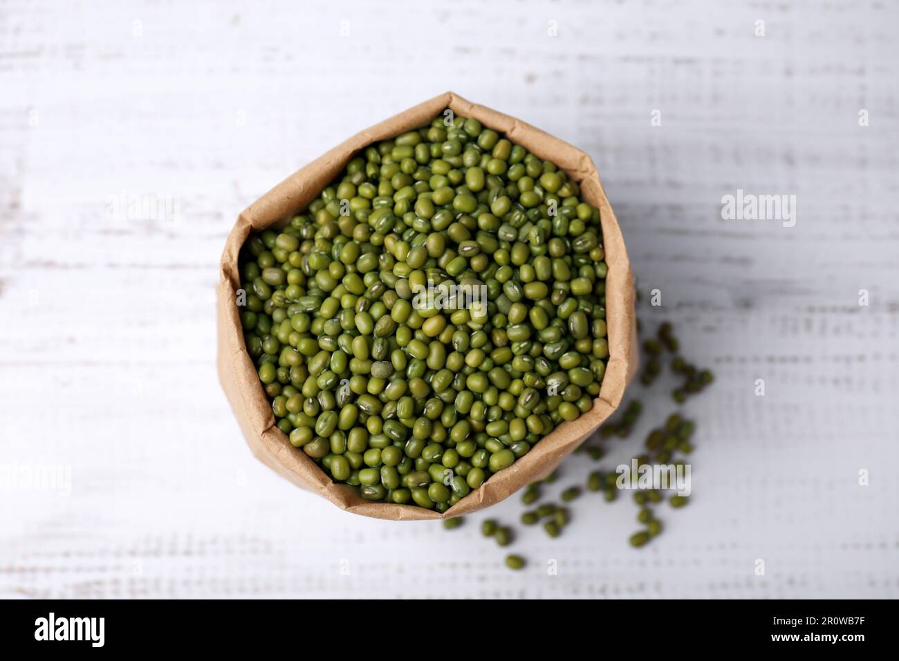 Paper bag with green mung beans on white wooden table, top view Stock ...