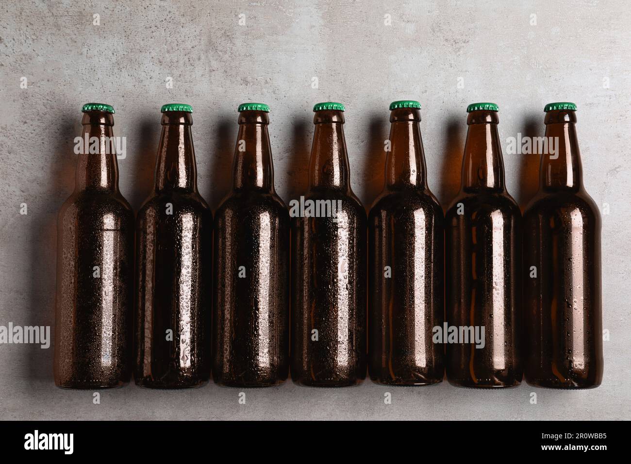 Glass bottles of beer on light grey background, flat lay Stock Photo ...