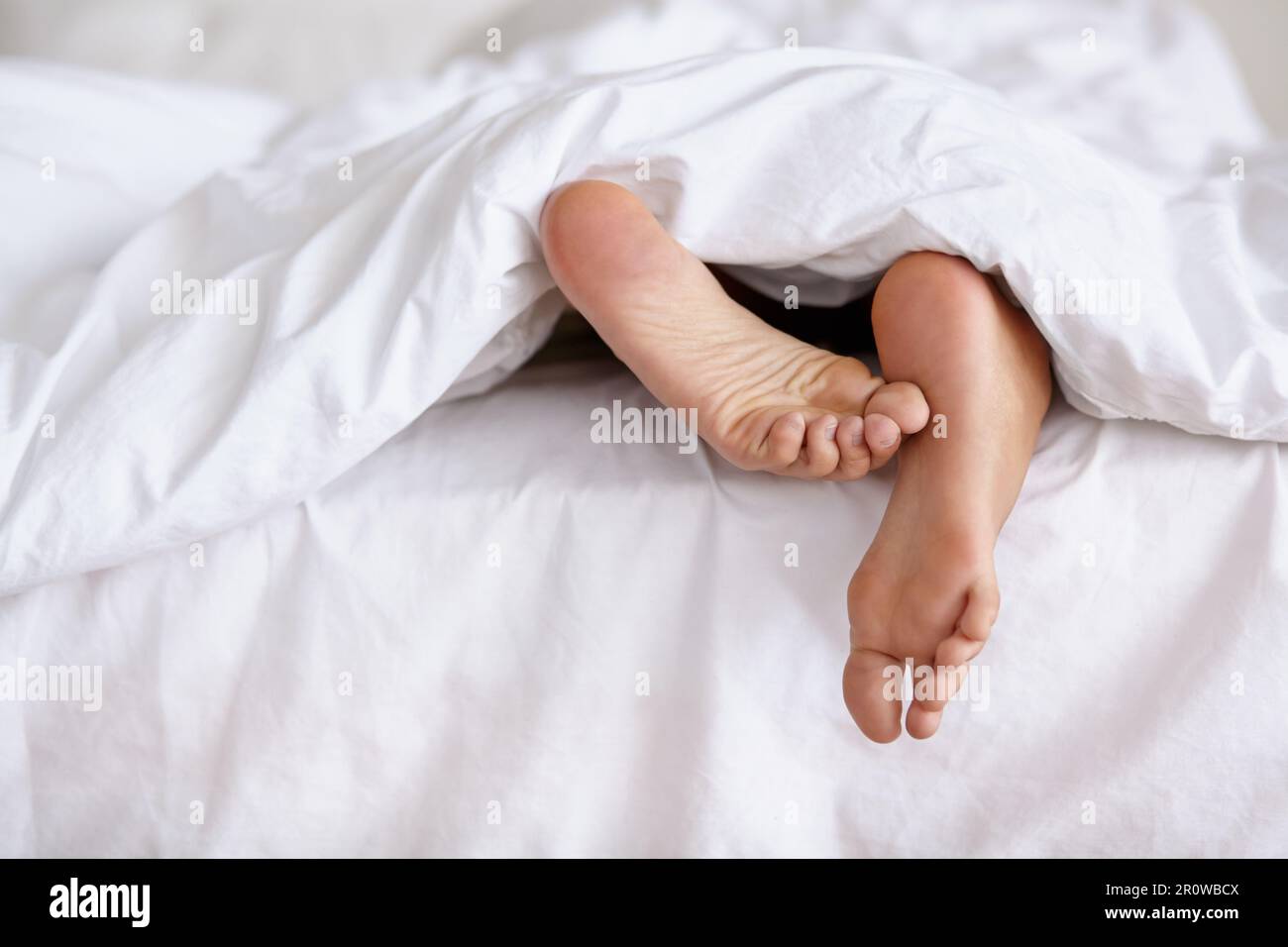 Wiggling toes of wakefulness. a pair of womans feet poking out from ...