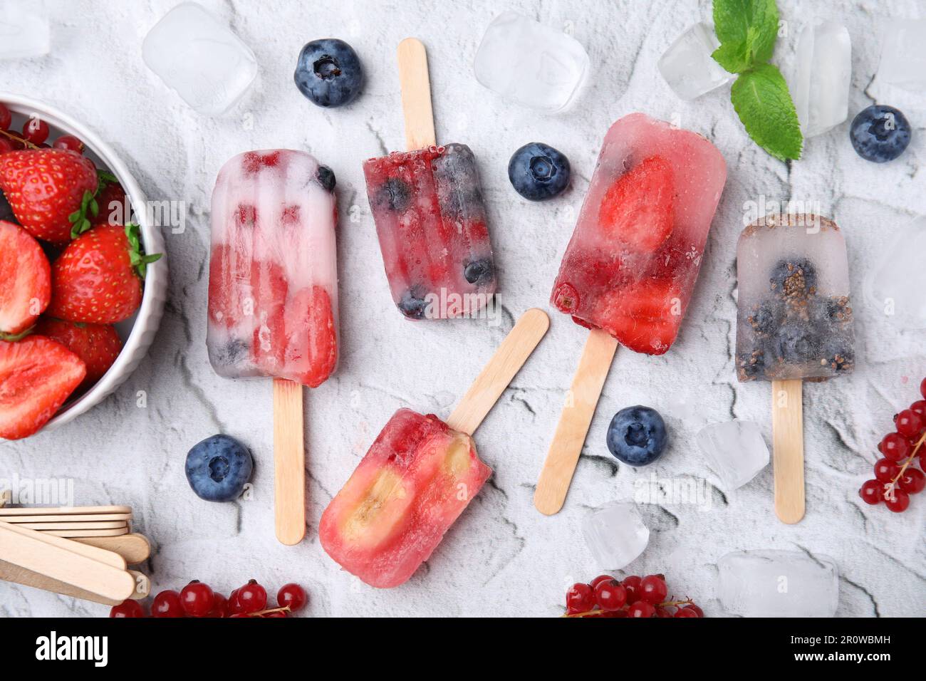 Flat lay composition with fruit and berry ice pops on light table Stock ...
