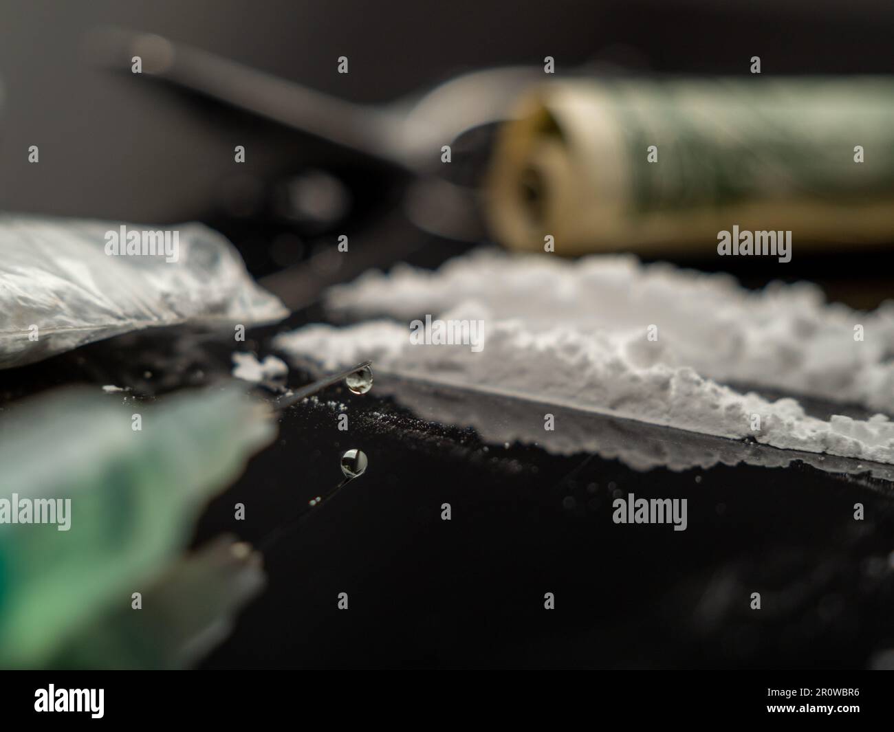 Syringe for injection and cocaine powder, on a black background. Drugs ...