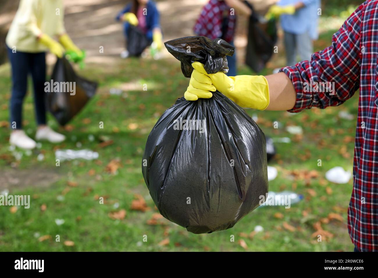 Man holding plastic bag with garbage in park, closeup Stock Photo - Alamy