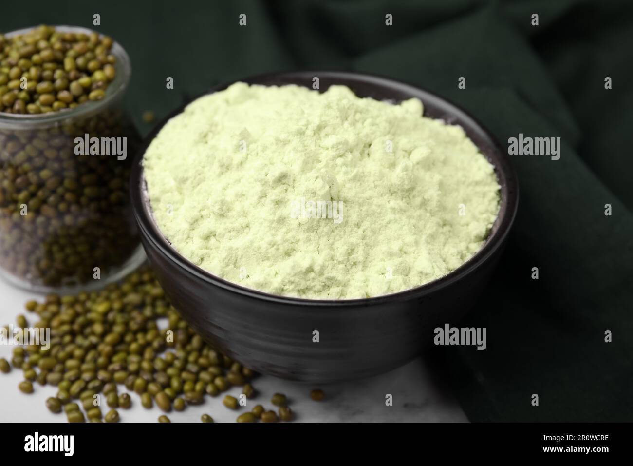 Mung bean flour in bowl and seeds on white marble table, closeup Stock ...
