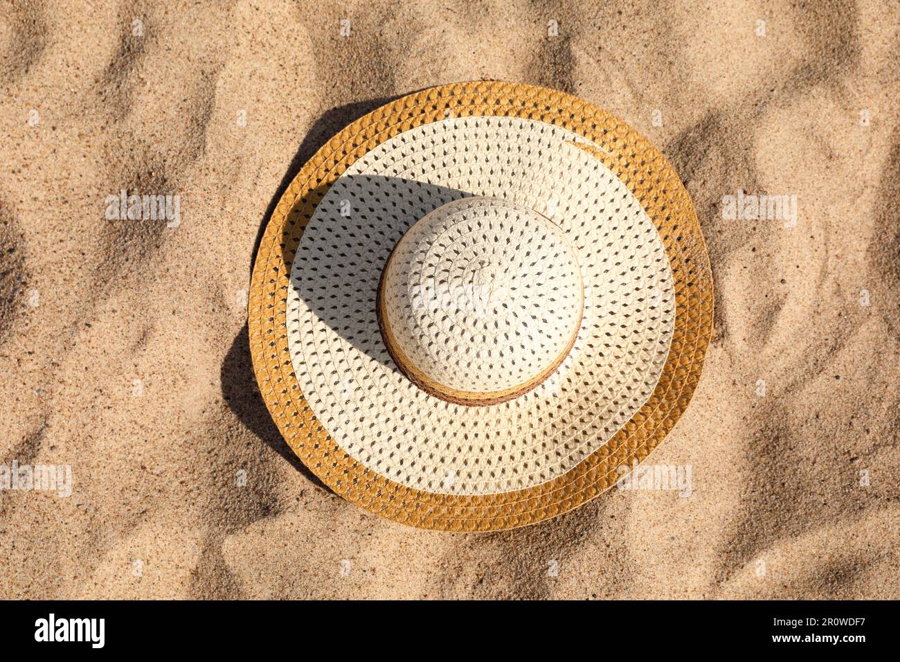 Beautiful beige straw hat on sand, top view Stock Photo - Alamy