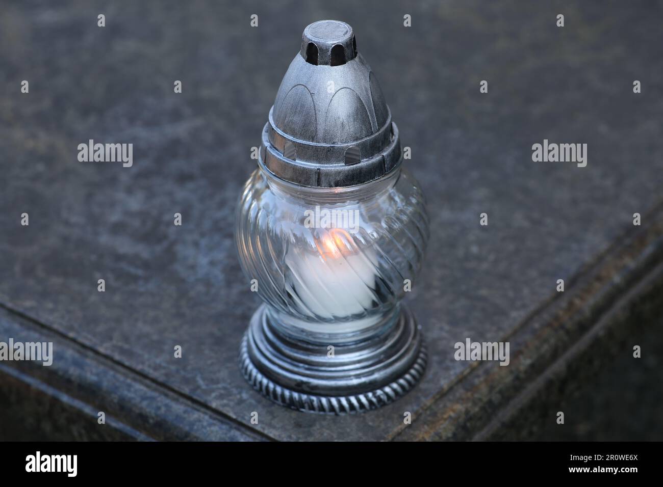 Grave lantern with burning candle on granite surface in cemetery Stock Photo - Alamy