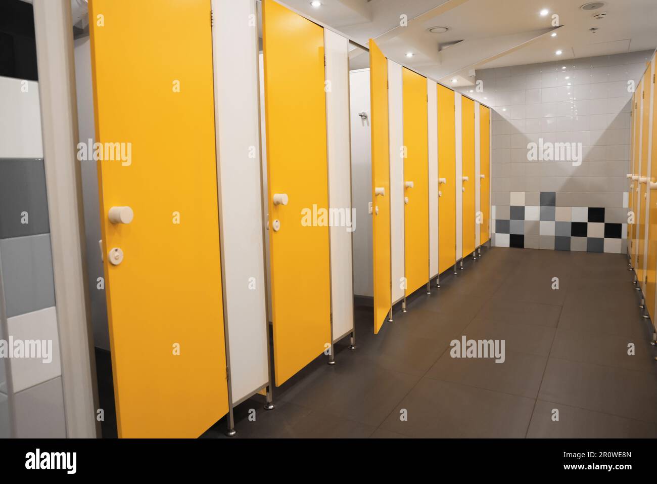 Public toilet interior with bright yellow stalls Stock Photo - Alamy